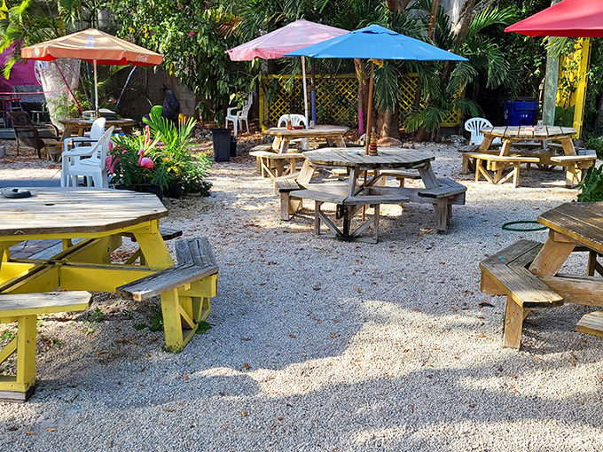 Wooden picnic tables under colorful umbrellas create the perfect spot to rest between treasure hunts or savor a key lime treat.