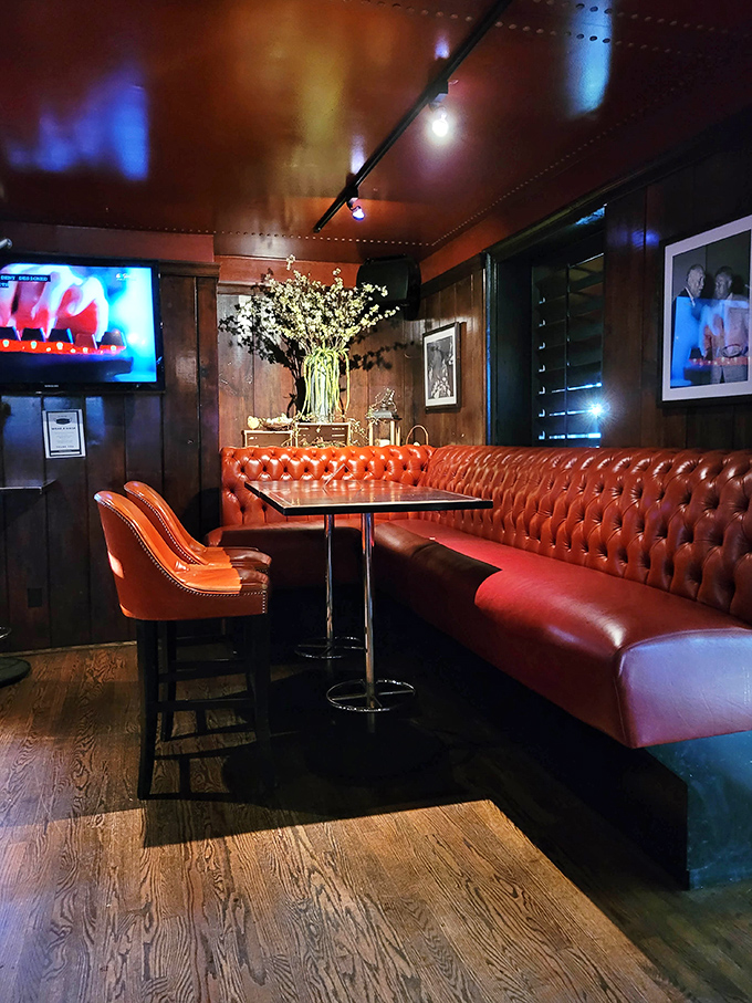 Red leather booths and warm wood tones create the perfect backdrop for conversations that linger longer than the meal itself.
