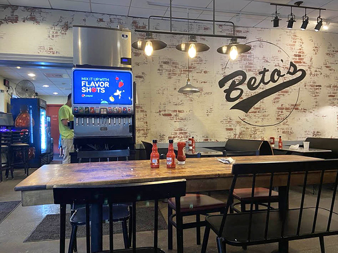 Modern meets tradition with rustic wooden tables and that illuminated soda machine standing sentinel. The brick wall has probably heard every "But the cheese is COLD?" conversation ever.