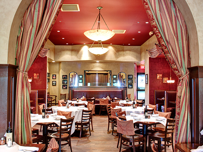 The rich red walls and elegant drapery of this dining section create a theatrical backdrop for the real stars of the show&mdash;the plates of pasta heading to eager tables.