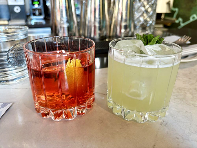 Cocktails that dress better than most people at a wedding. The ruby-red Negroni and its citrusy companion are liquid personality tests in crystal glasses.