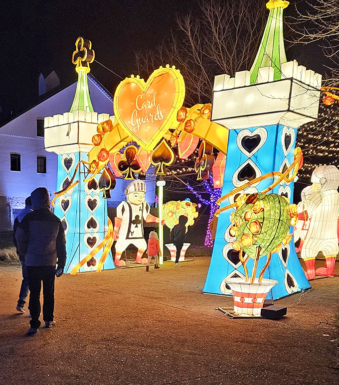 When night falls, the wonderland awakens with illuminated card guards standing sentinel over this kingdom of whimsy.