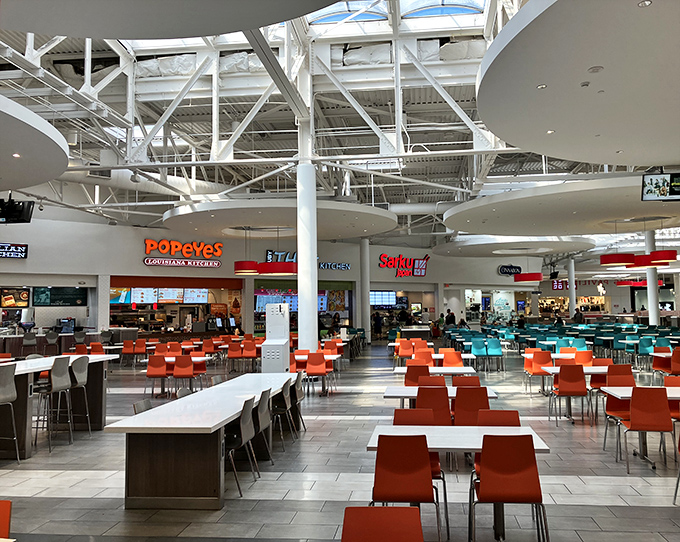The food court: where shopping warriors refuel amid a symphony of international cuisines. Those orange chairs have heard many victory tales.