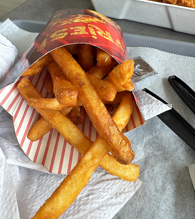 Golden fries that somehow maintain their structural integrity while delivering that perfect crisp-outside, fluffy-inside experience.