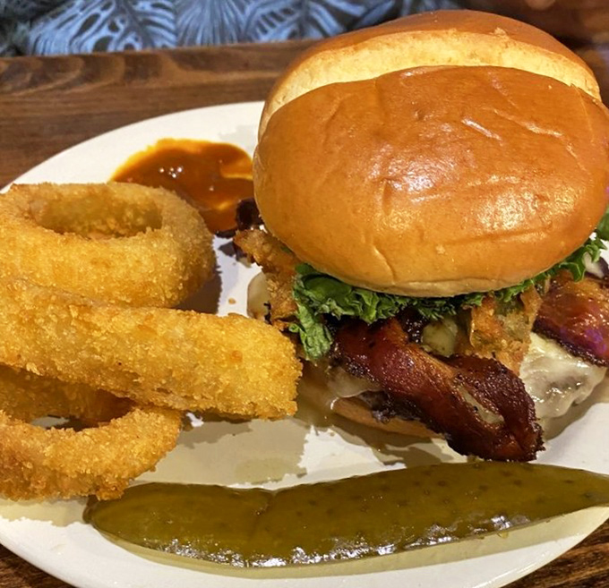 This isn't just a burger; it's an architectural marvel of beef, bacon, and crispy onion rings that requires both hands and possibly a strategy session.