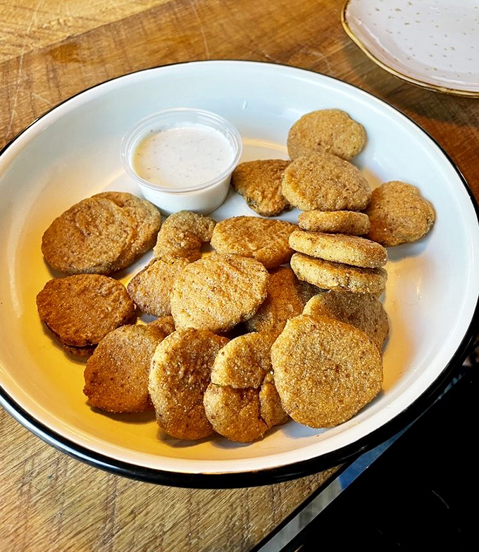 Fried pickle chips that deliver the perfect trifecta: crunchy exterior, tangy interior, and a dipping sauce that ties the whole relationship together.