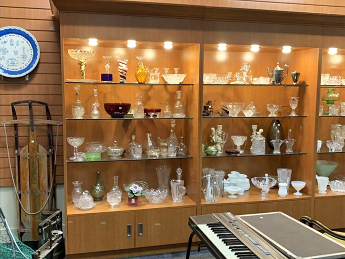 Crystal and glassware sparkle under fluorescent lights, ready to elevate someone's next dinner party.