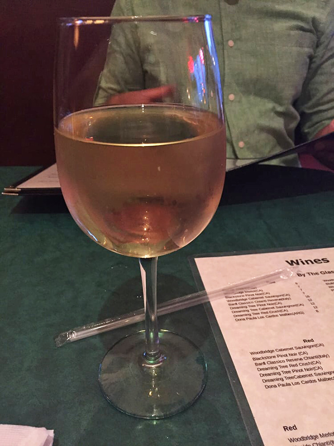 A glass of white wine alongside the wine list&mdash;because what's a proper Italian meal without the perfect grape companion? Salute to simple pleasures!
