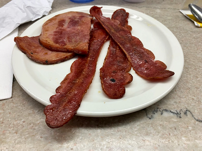 Bacon and ham sharing a plate like old friends at a reunion. This is breakfast meat done right – no fancy smoke, no artisanal cure, just pure morning protein perfection.