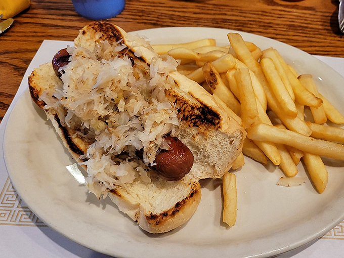 A hot dog nestled in a toasted bun with a mountain of sauerkraut&mdash;proof that simple pleasures are often the most satisfying.