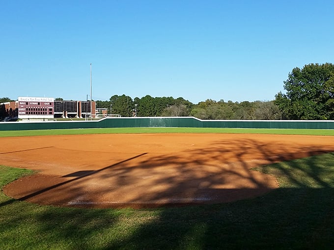 Friday night lights shine on this well-maintained baseball field, where community sports create memories worth far more than the price of admission.