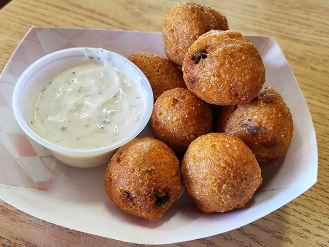 Hush puppies with that perfect crispy exterior giving way to a soft, savory interior &ndash; the comfort food you didn't know you were missing your entire life.