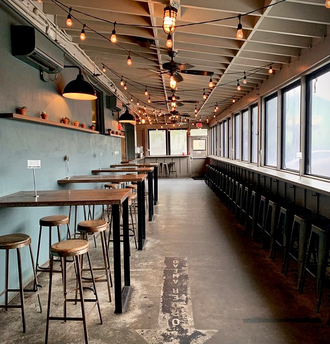 String lights dance overhead in this industrial-chic dining space where high-top tables invite lingering conversations over the last bites of brisket.