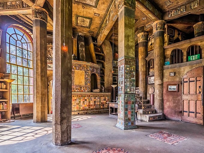 Massive concrete pillars rise like ancient trees in this grand hall, where every surface tells a story through embedded tiles and artifacts.