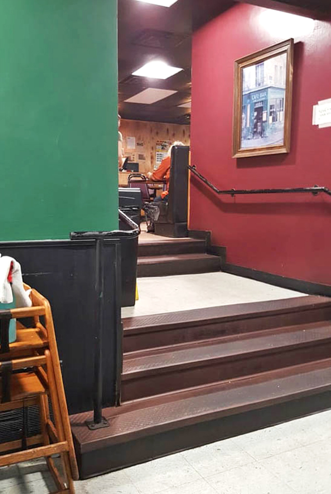 Bold red and green walls frame the split-level seating arrangement that maximizes space without sacrificing that intimate diner atmosphere.