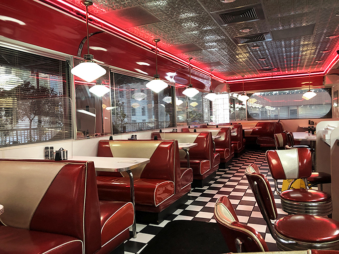 The diner's interior glows with that distinctive red neon warmth, creating an atmosphere where calories don't count and breakfast decisions are the day's biggest challenge.
