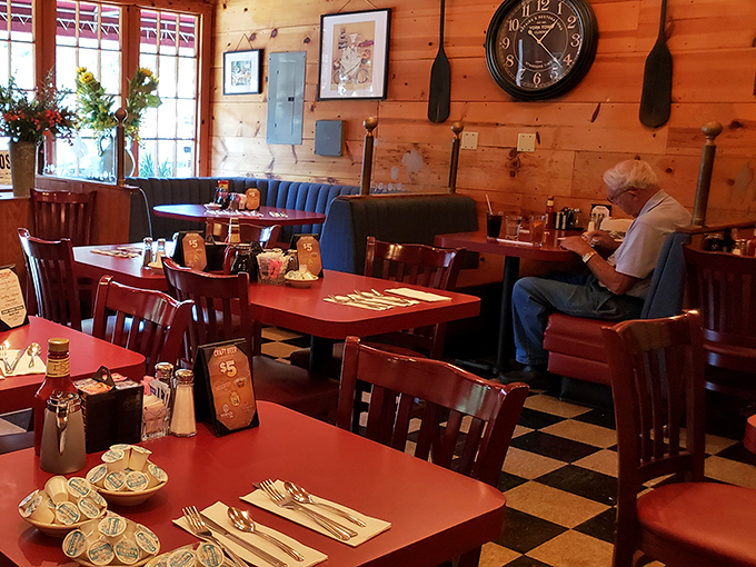 Red tables, blue booths, and wooden walls create a dining room that feels like a mountain cabin crossed with your favorite childhood diner.