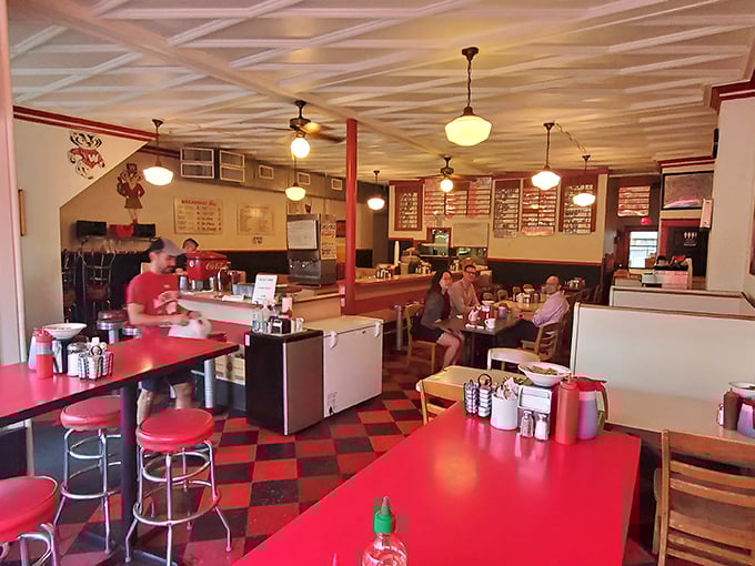 The classic red and black checkered floor sets the stage for culinary nostalgia, while pendant lights cast a warm glow over happy diners.