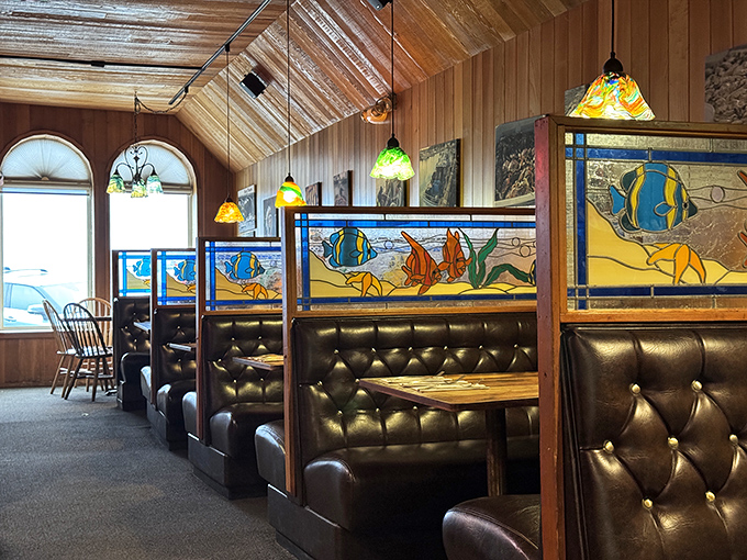 Nautical-themed stained glass dividers and cushioned booths create cozy dining nooks where seafood memories are made and shared.