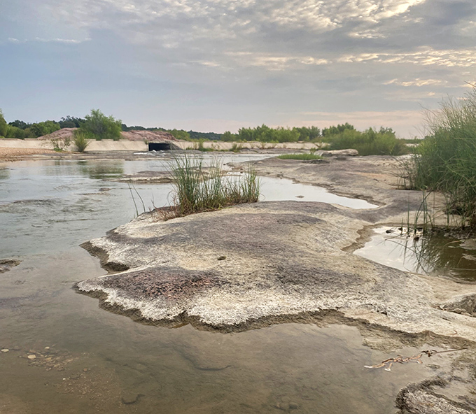 The Llano River flows like liquid silver across ancient rock beds, a timeless current that shaped both landscape and community.