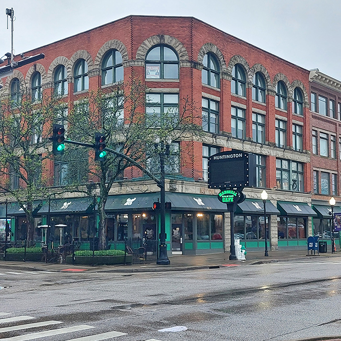 This historic building anchors a downtown corner with brick-and-mortar confidence. The green awnings add a touch of welcoming contrast to the urban landscape.