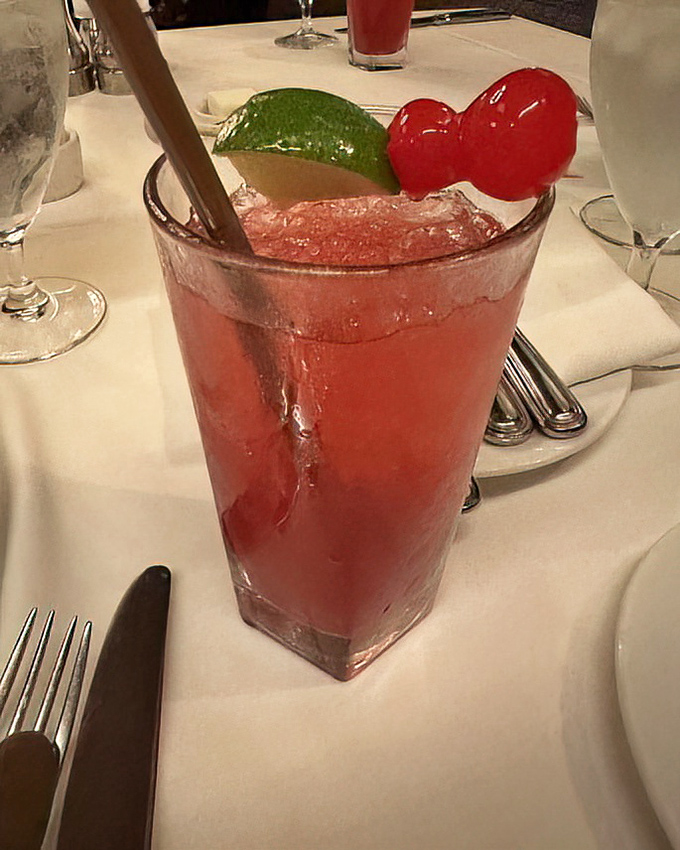 A ruby-red cocktail garnished with lime and cherries &ndash; proof that what happens before the steak can be just as important as the main event.