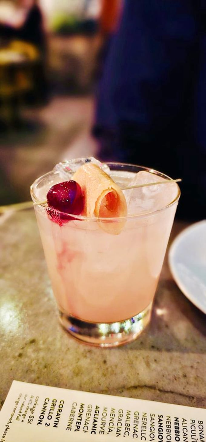 A cocktail that's dressed better than most people at the Oscars. That citrus curl and cherry are the accessories this drink deserves.