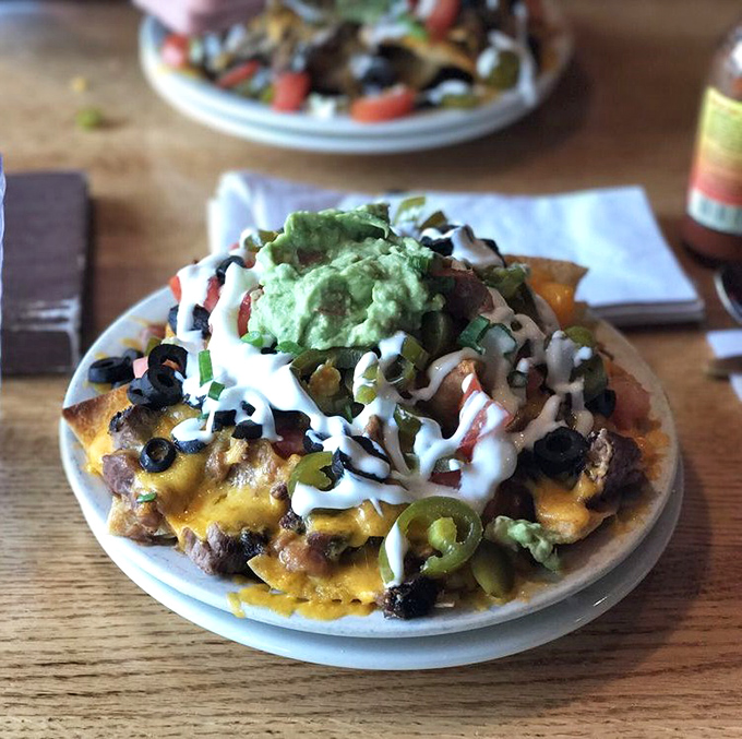 Nachos piled so high they need their own zip code, topped with everything but the kitchen sink.