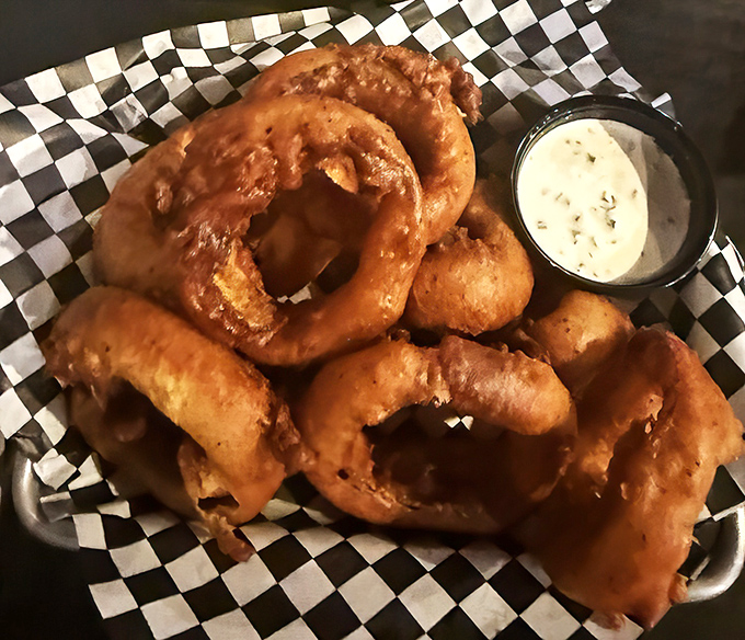 Golden, crispy onion rings that crunch loud enough to turn heads. That dipping sauce isn't optional&mdash;it's essential to the experience.