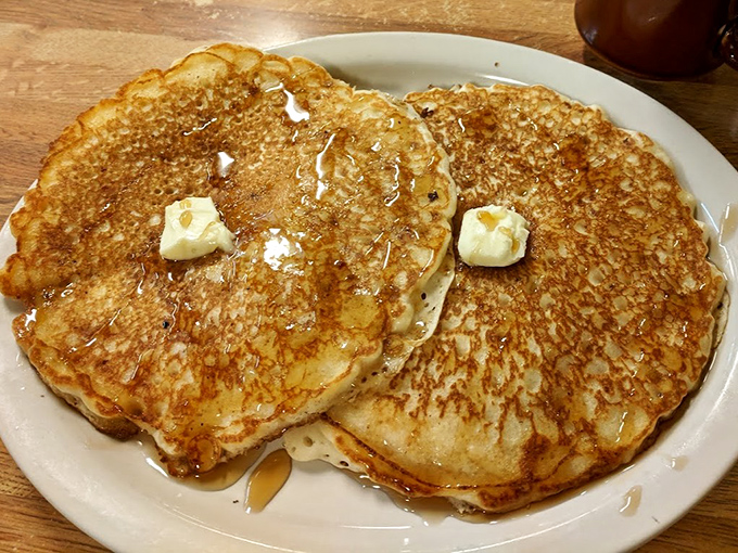 Golden pancakes that look like they've been kissed by the morning sun, with butter melting into their fluffy centers like a warm embrace.