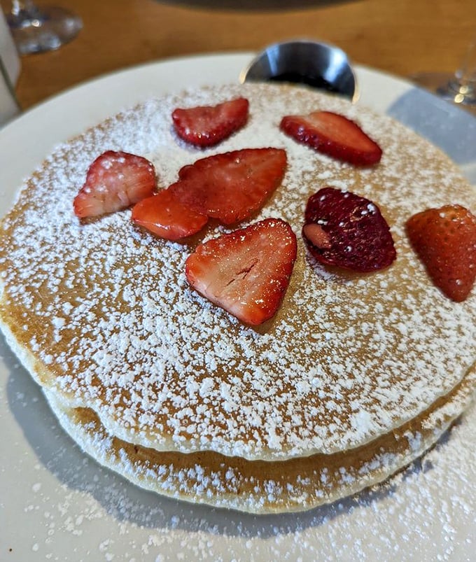 Pancakes dusted with powdered sugar and crowned with fresh strawberries. Simple perfection that reminds you why classics never go out of style.