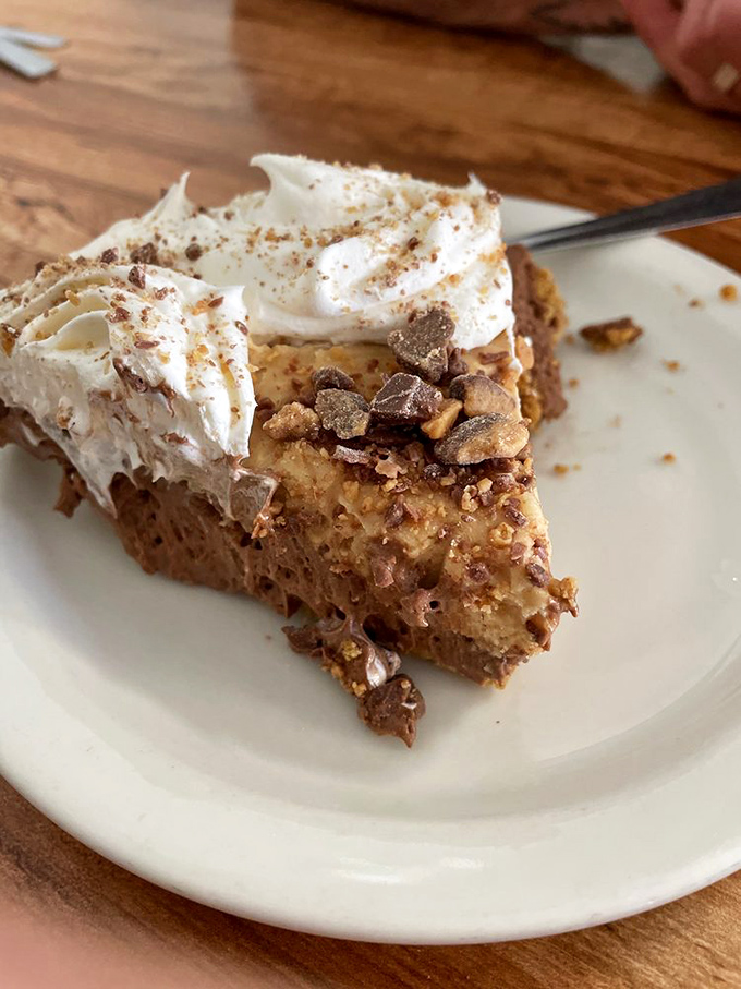 A slice of peanut butter pie with whipped cream and crumbled toppings that would make Elvis weep with joy.