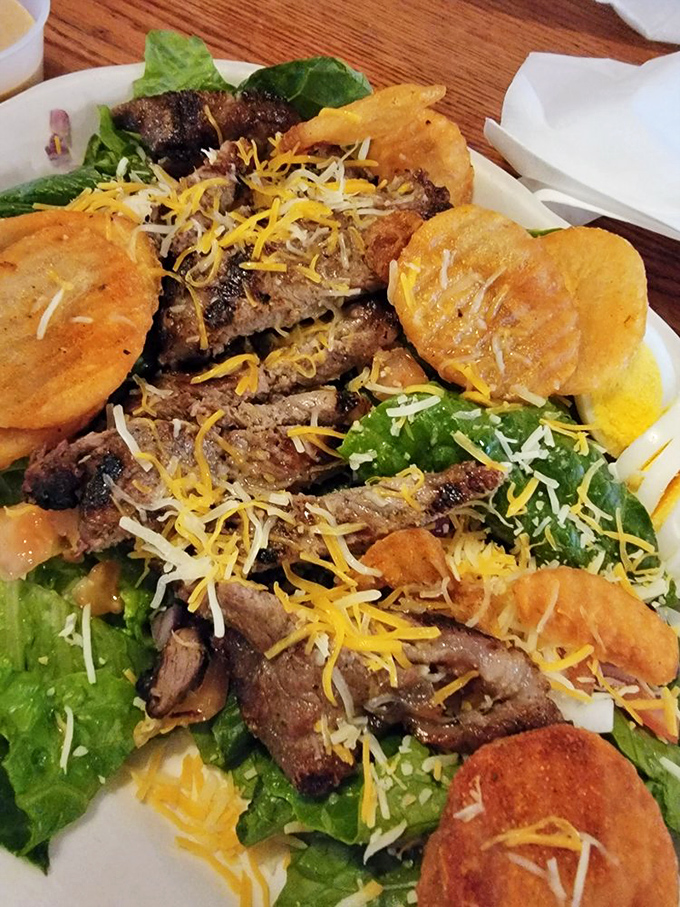 The Pittsburgh Steak Salad brings Pennsylvania flair with marinated steak, cottage fries, and a rainbow of fresh vegetables under a blanket of cheese.