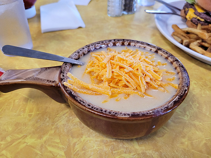 A bowl of potato soup topped with shredded cheddar&mdash;comfort that arrives by spoon and warms you from the inside out.