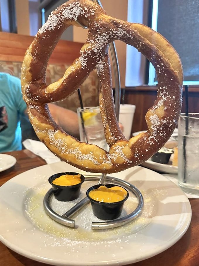 This isn't just a pretzel&mdash;it's architecture you can eat. Hanging majestically like a carb chandelier above its mustard companions.