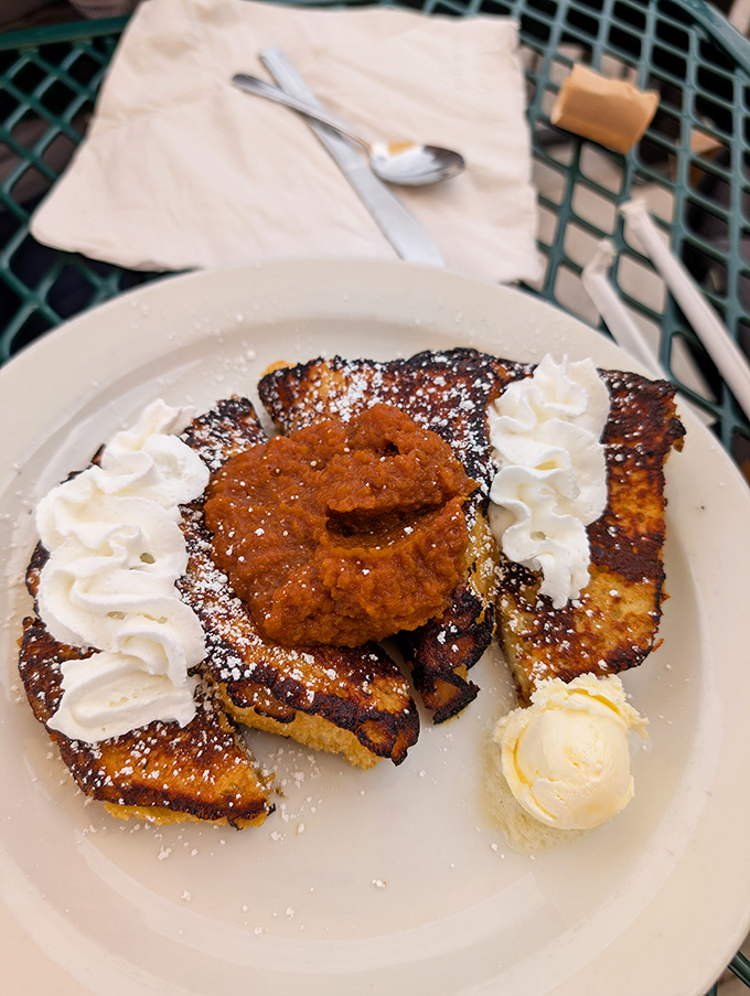 French toast that looks like it's dressed for a special occasion, complete with whipped cream sentinels standing guard over pumpkin goodness.