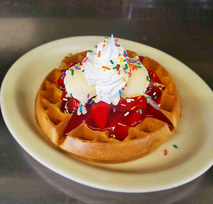 A rainbow waffle topped with strawberries and whipped cream &ndash; because breakfast should always include a little magic. 