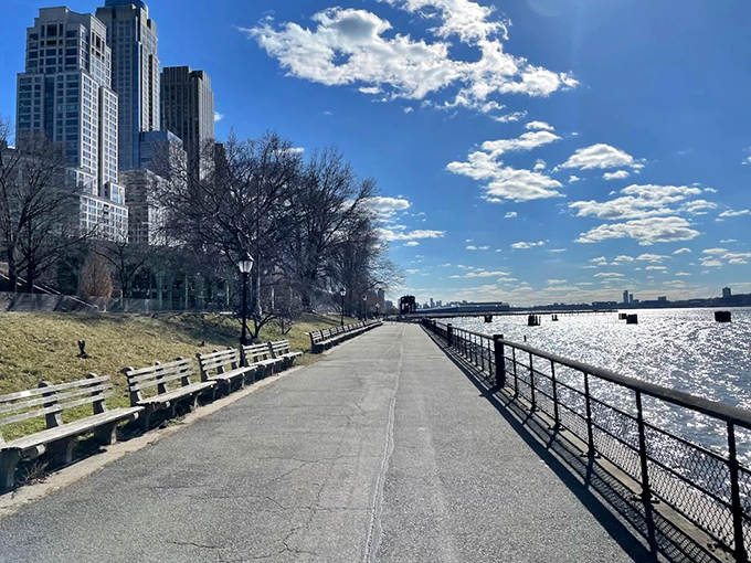 Riverside pathways offer urban amenities without urban stress, proving waterfront living doesn't require Manhattan real estate prices.