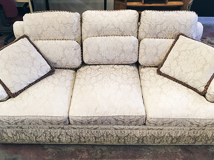 This sofa has seen things. With its regal damask upholstery and braided trim, it's waiting for someone to appreciate its vintage charm.