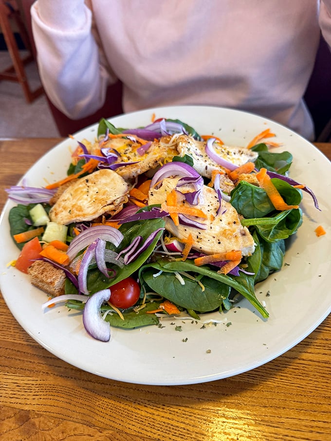 A spinach salad that doesn't feel like punishment, topped with grilled chicken that makes eating greens feel like a choice, not a chore.