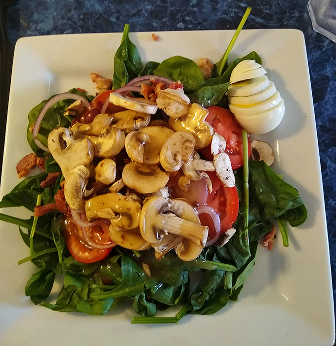 A spinach salad that doesn't apologize for being healthy, loaded with fresh mushrooms, eggs, and veggies that brighten the plate.