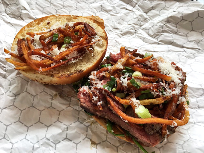 Steak, crispy shoestring potatoes, and greens on a roll? It's like someone turned a fancy steakhouse dinner into portable happiness.