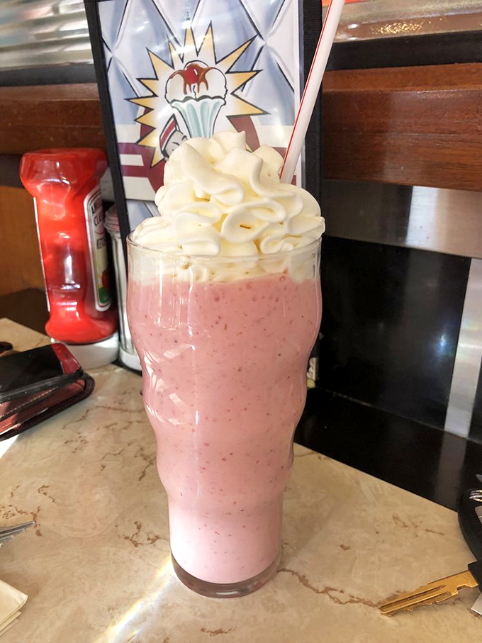 That strawberry milkshake is basically happiness in a glass, topped with enough whipped cream to prove it.