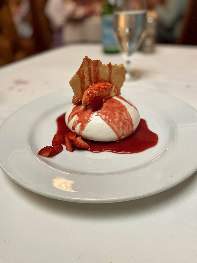 This isn't just dessert; it's architecture &ndash; a delicate pavlova crowned with fresh berries that shatters with each spoonful like sweet, edible glass.