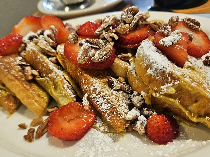 French toast topped with strawberries and pecans, transforming breakfast into something between comfort and celebration.