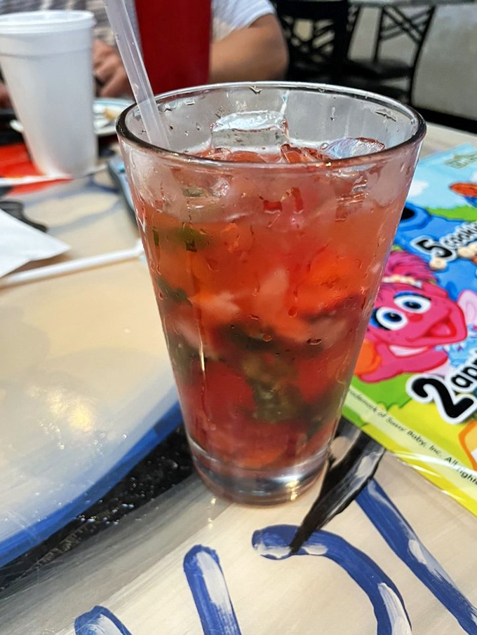 This ruby-red cocktail, studded with fresh herbs, offers a sweet-tart respite from the briny bounty of the sea.