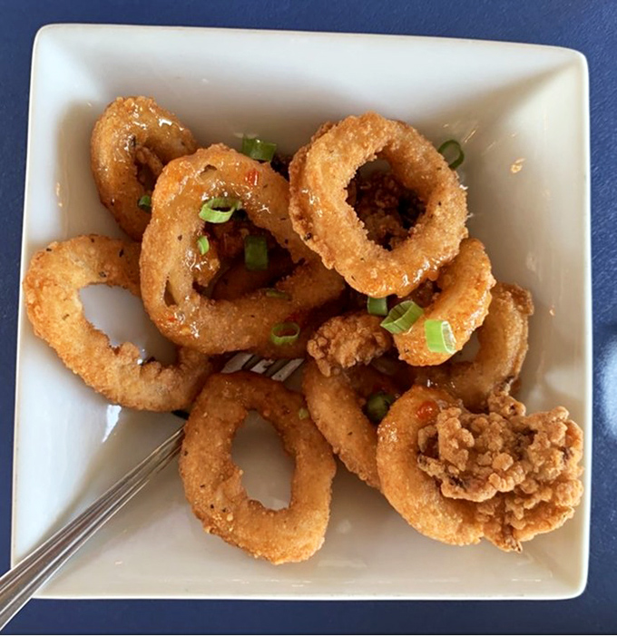 Crispy calamari rings that crunch like nature's perfect snack food. Garnished with scallions, these golden hoops disappear faster than you can say "another round."