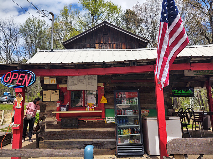 Village Ice Cream's rustic cabin serves nostalgia by the scoop – complete with American flag and front-porch hospitality.