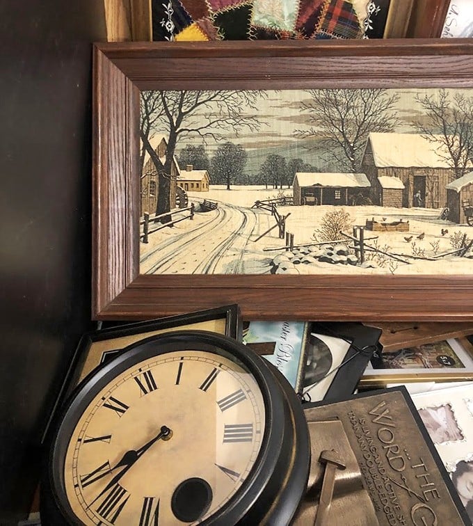 Vintage treasures stack together like a time capsule buffet. That clock and winter scene could transport your living room to another era entirely.
