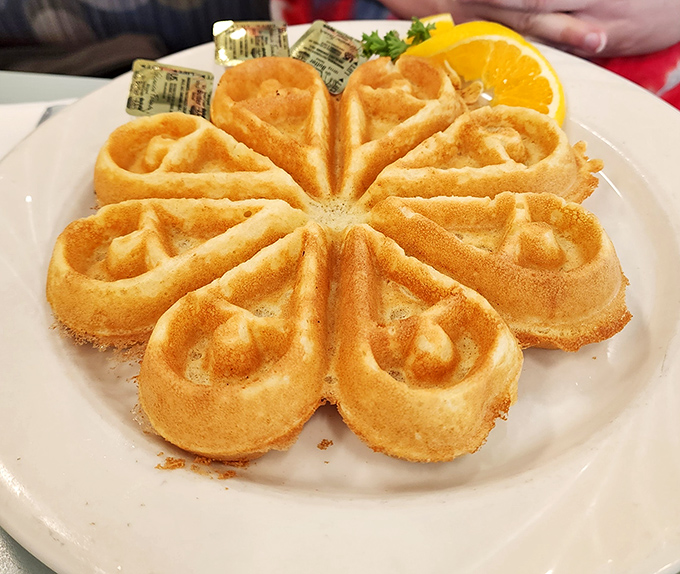 The golden flower-shaped waffle isn't just breakfast&mdash;it's edible morning sunshine that makes syrup application a strategic art form.